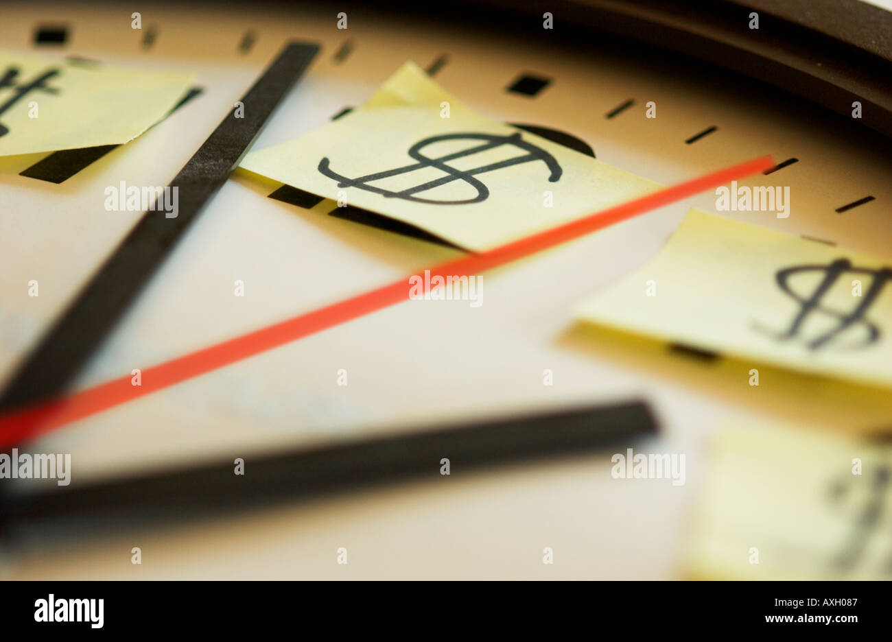 closeup of office clock with dollar signs sticky notes hiding numbers ...