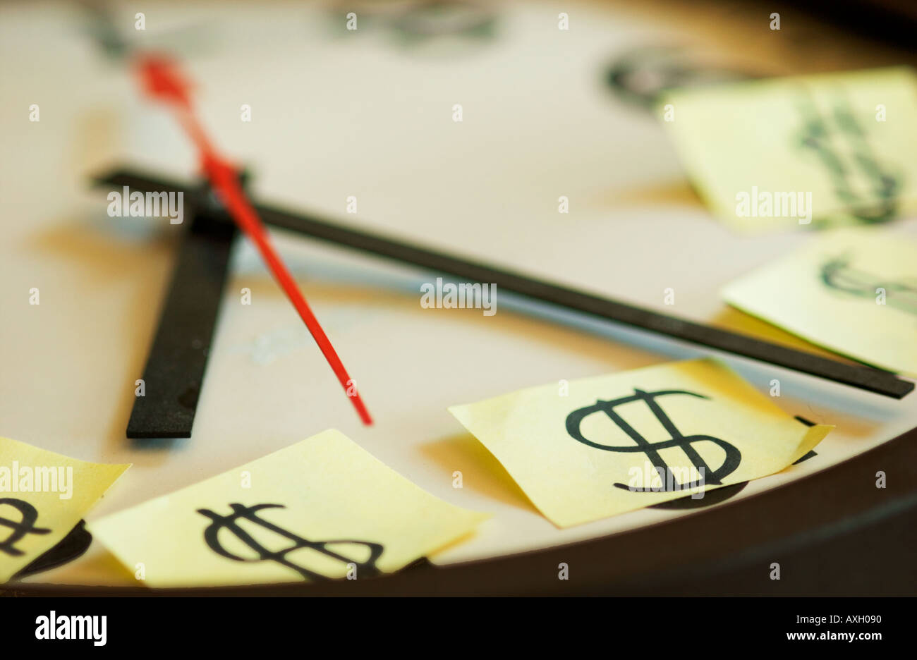 closeup of office clock with dollar signs sticky notes hiding numbers ...