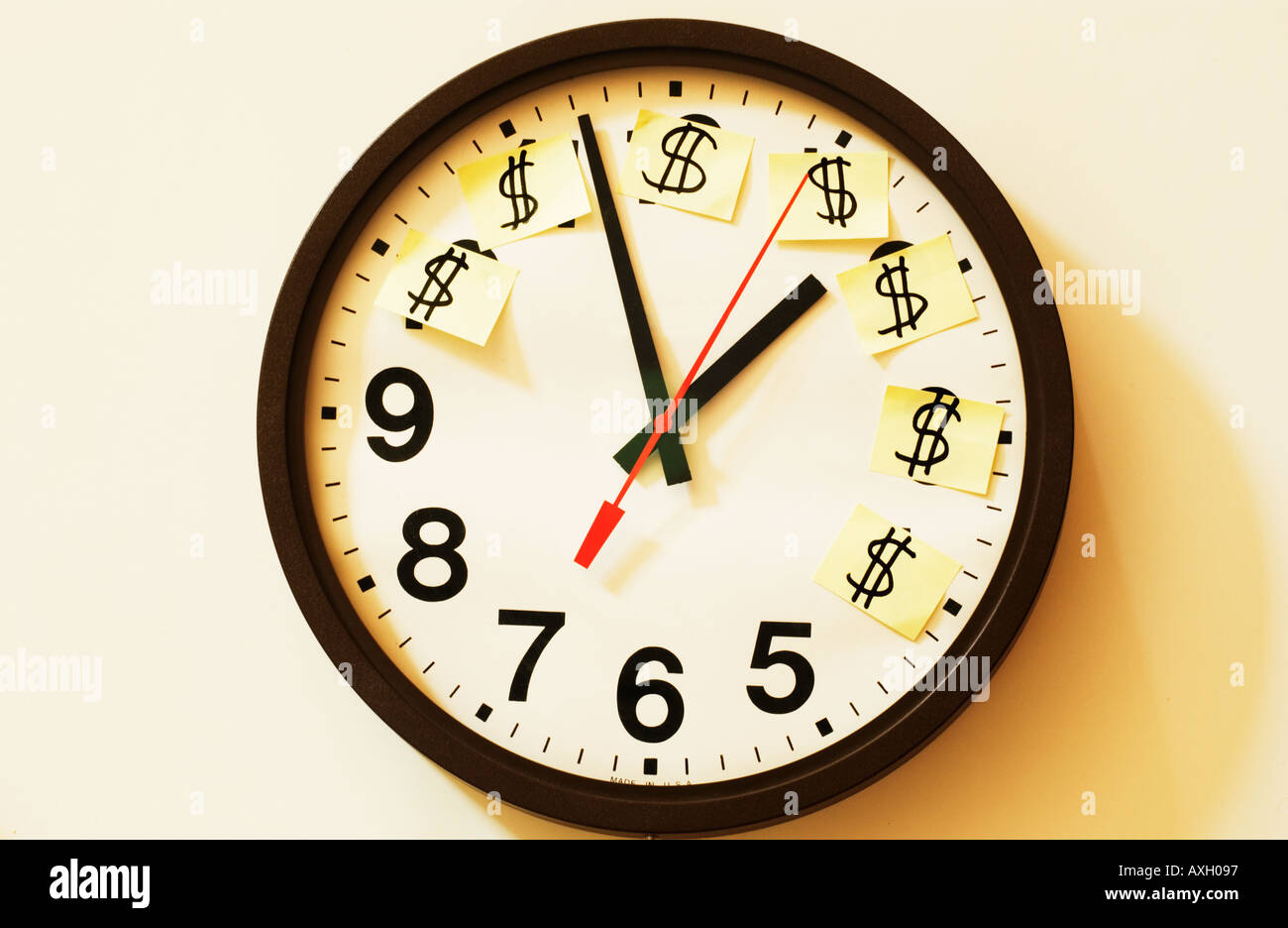 closeup of office clock with dollar signs sticky notes hiding numbers ...