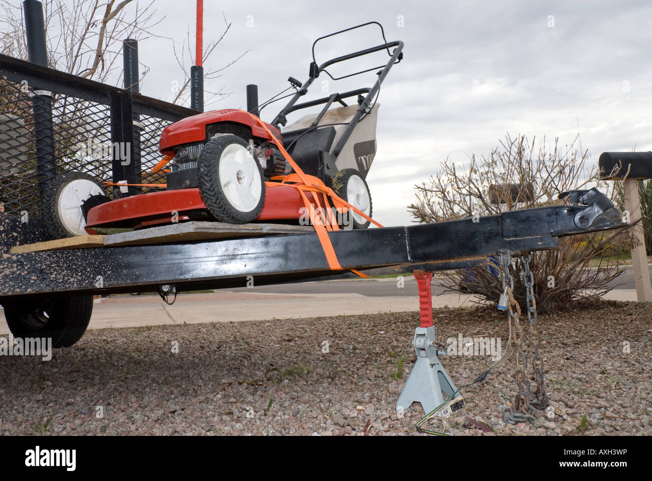 A lawn mower rests on a platform on the trailer of a gardners truck ...