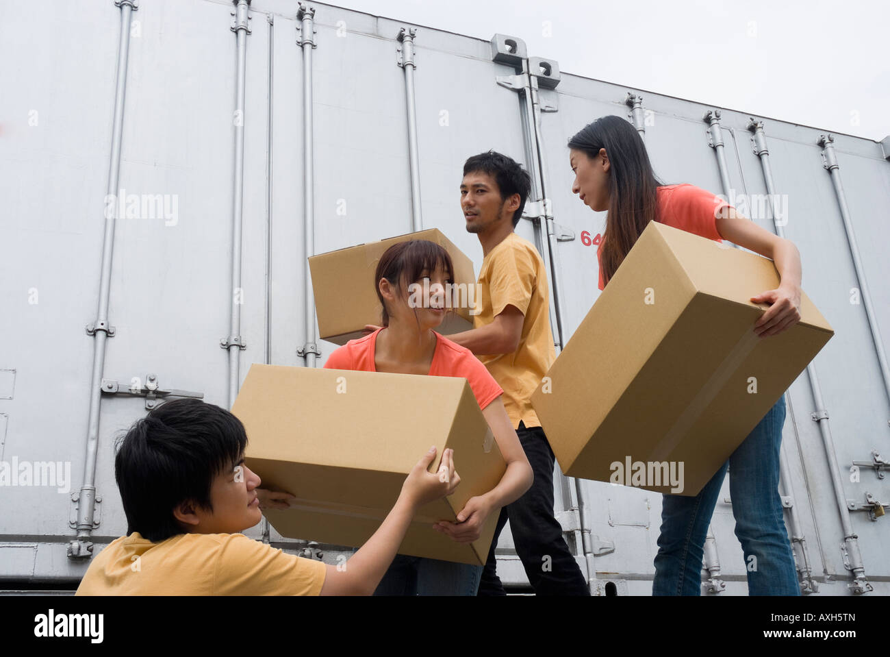 Young people carrying boxes Stock Photo - Alamy