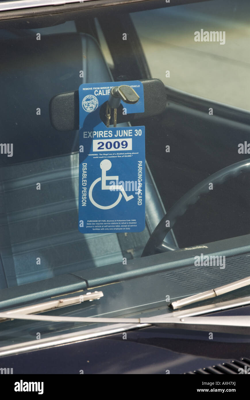 Disabled parking placard hanging from mirror Stock Photo - Alamy