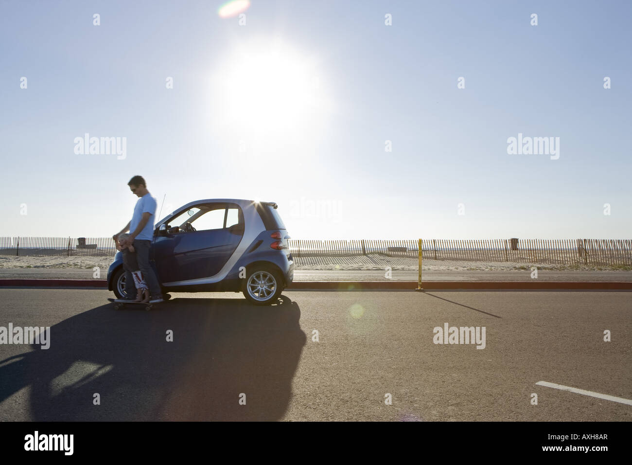 Man and son at beach with Smartcar compact car Stock Photo - Alamy
