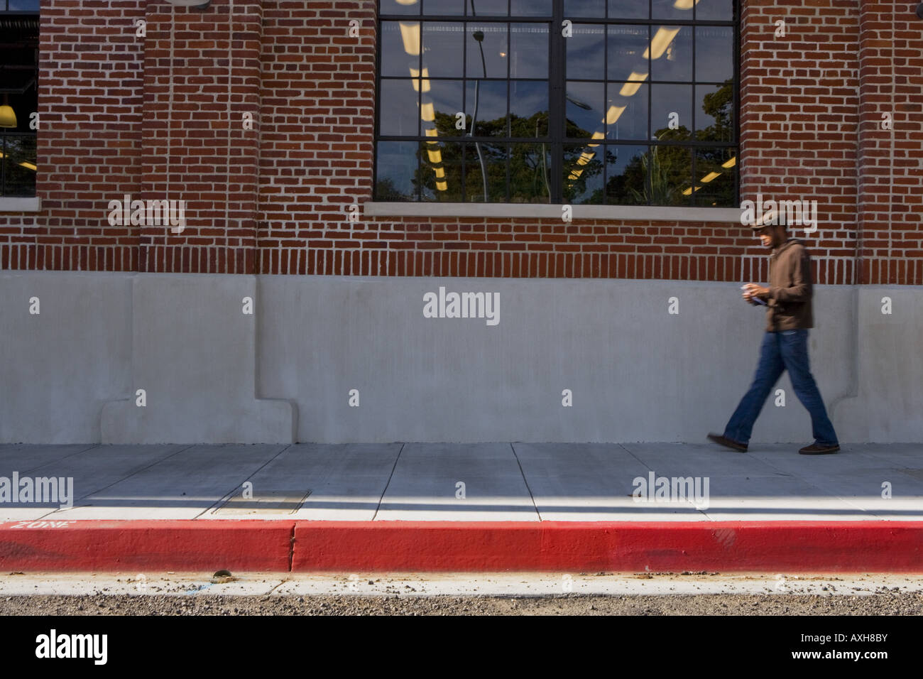 Man walking on sidewalk Stock Photo - Alamy