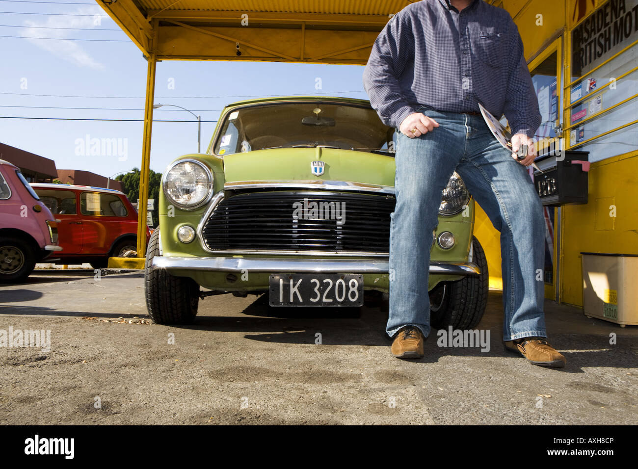 Man sitting on hood of vintage Mini Cooper Stock Photo - Alamy