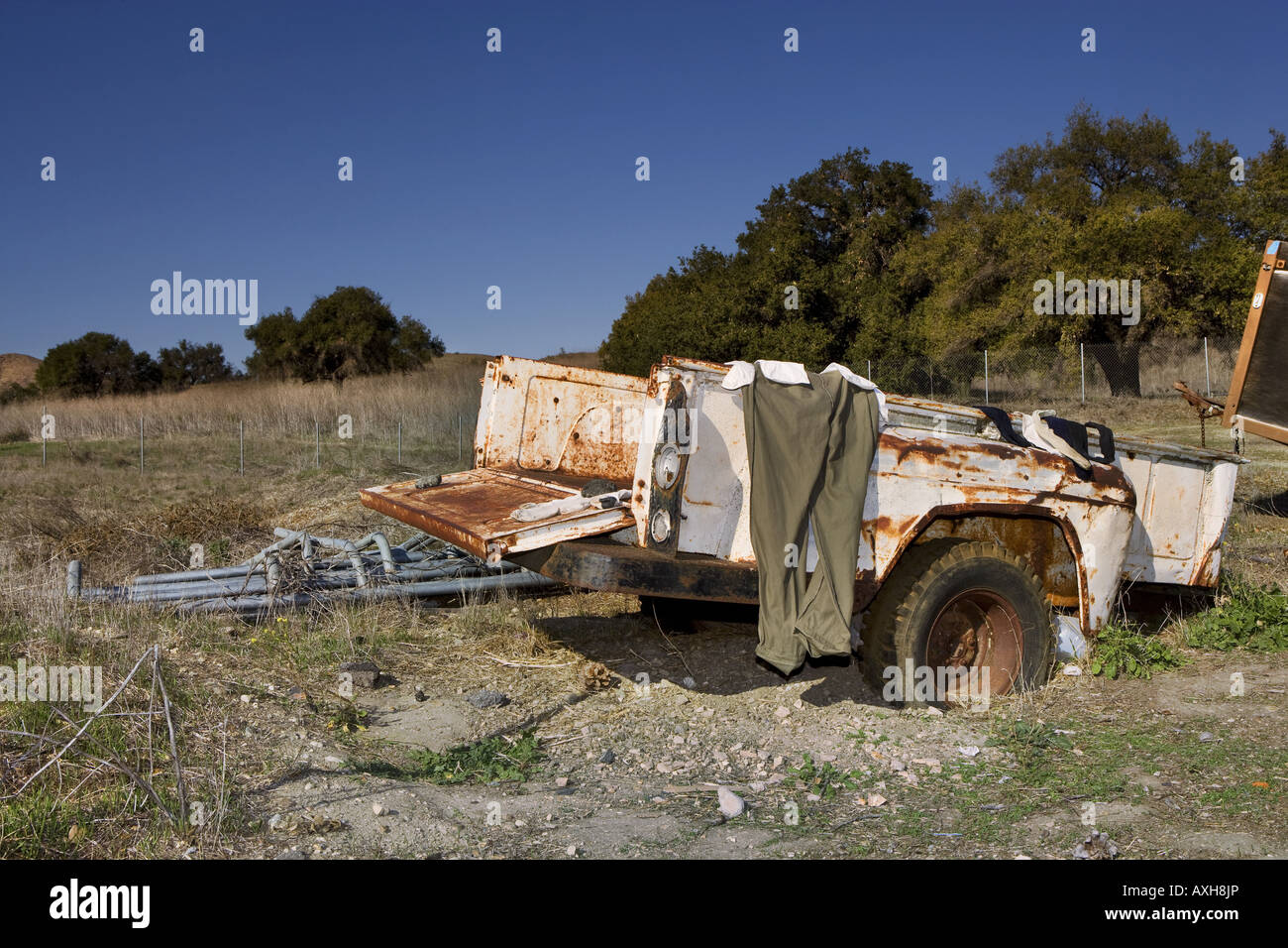 Rusty trailer with trousers in field Stock Photo - Alamy