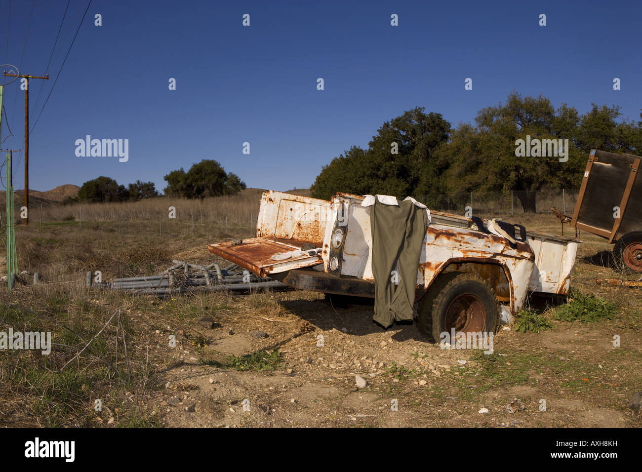 Rusty trailer with trousers in field Stock Photo - Alamy