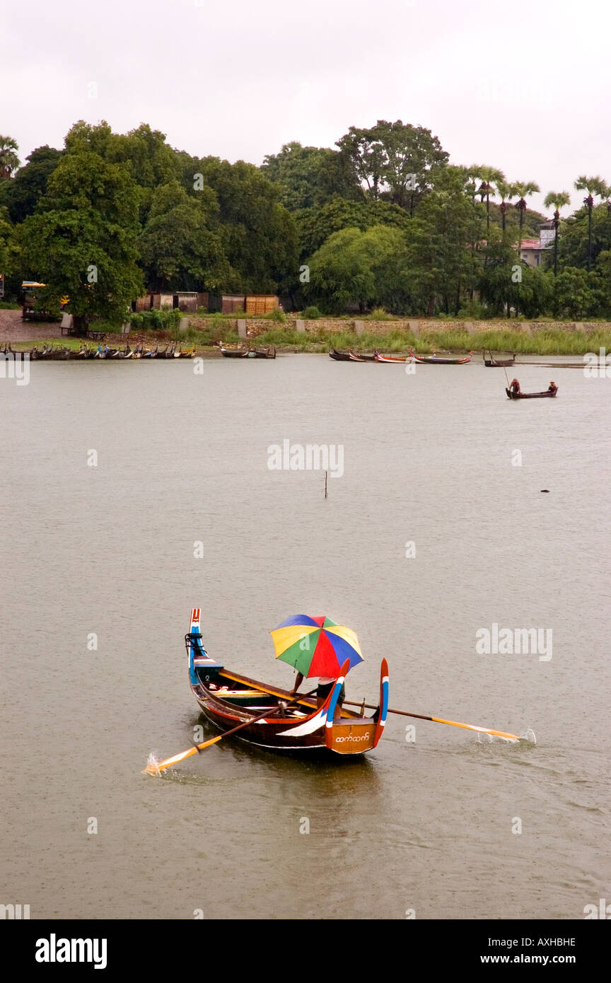 Stock photograph of a man rowing a tourist boat in the rain at ...