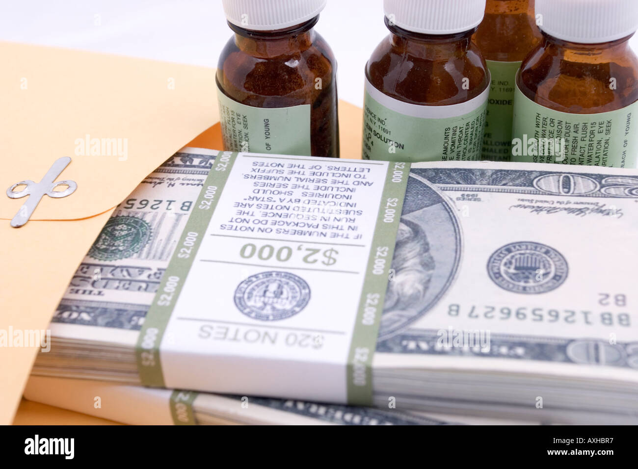 Bundles of cash next to small bottles Stock Photo - Alamy