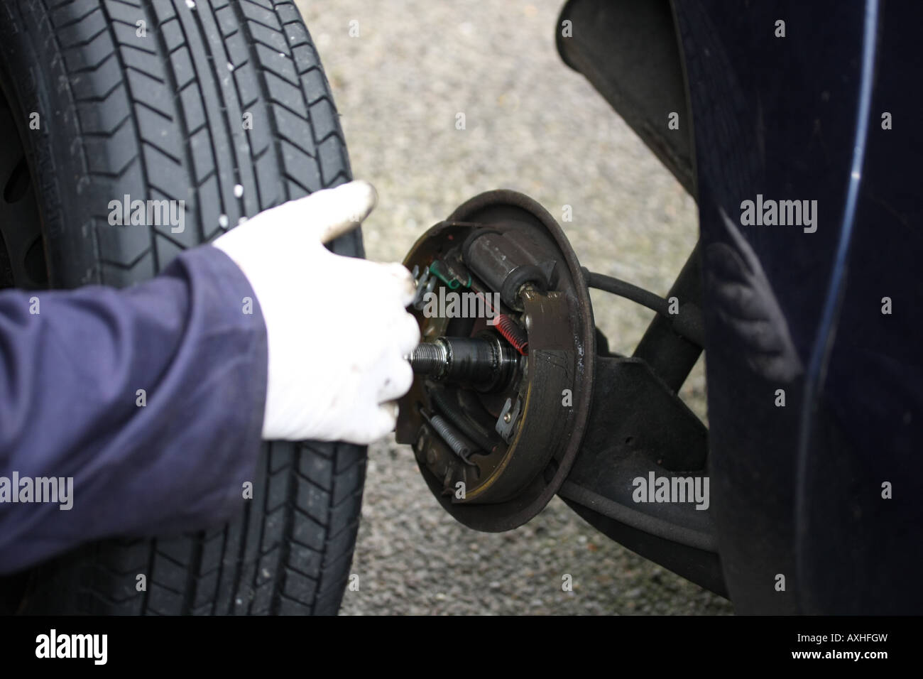 Car Mechanic Removing wheel and inspecting brakes on car Stock Photo ...