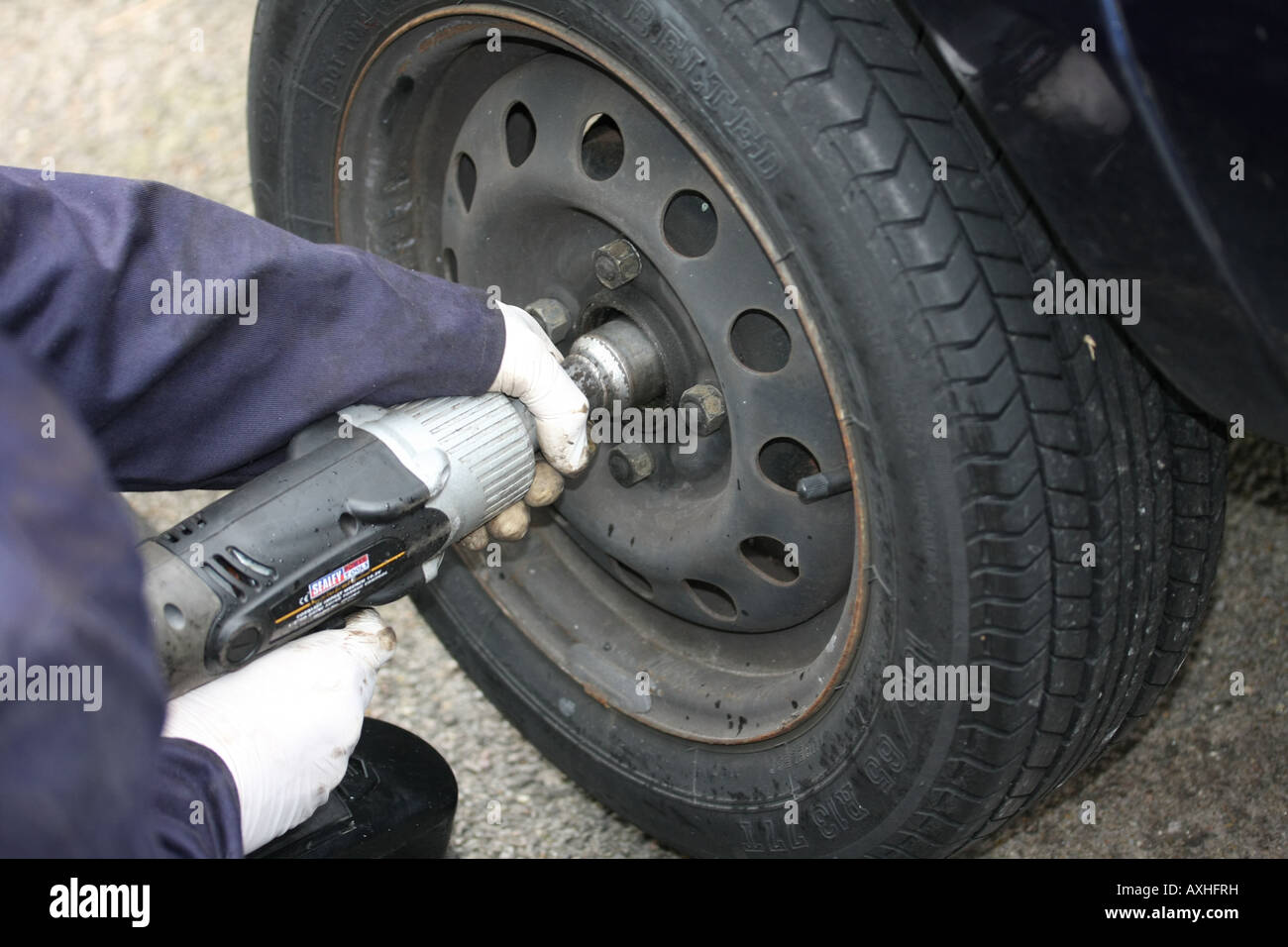 Car Mechanic Removing wheel and inspecting brakes on car Stock Photo ...