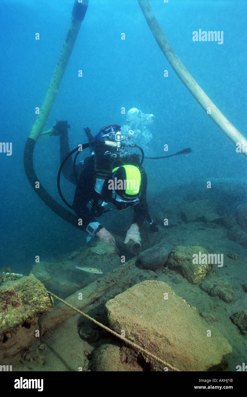 scubadiver carrying out excavations in an underwater archeological site ...