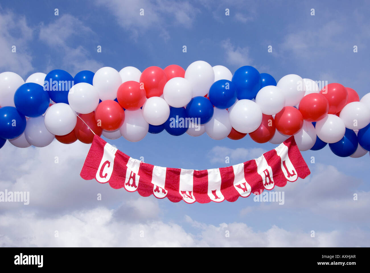 Floating balloons on a streamer arch across the opening of a park for a ...