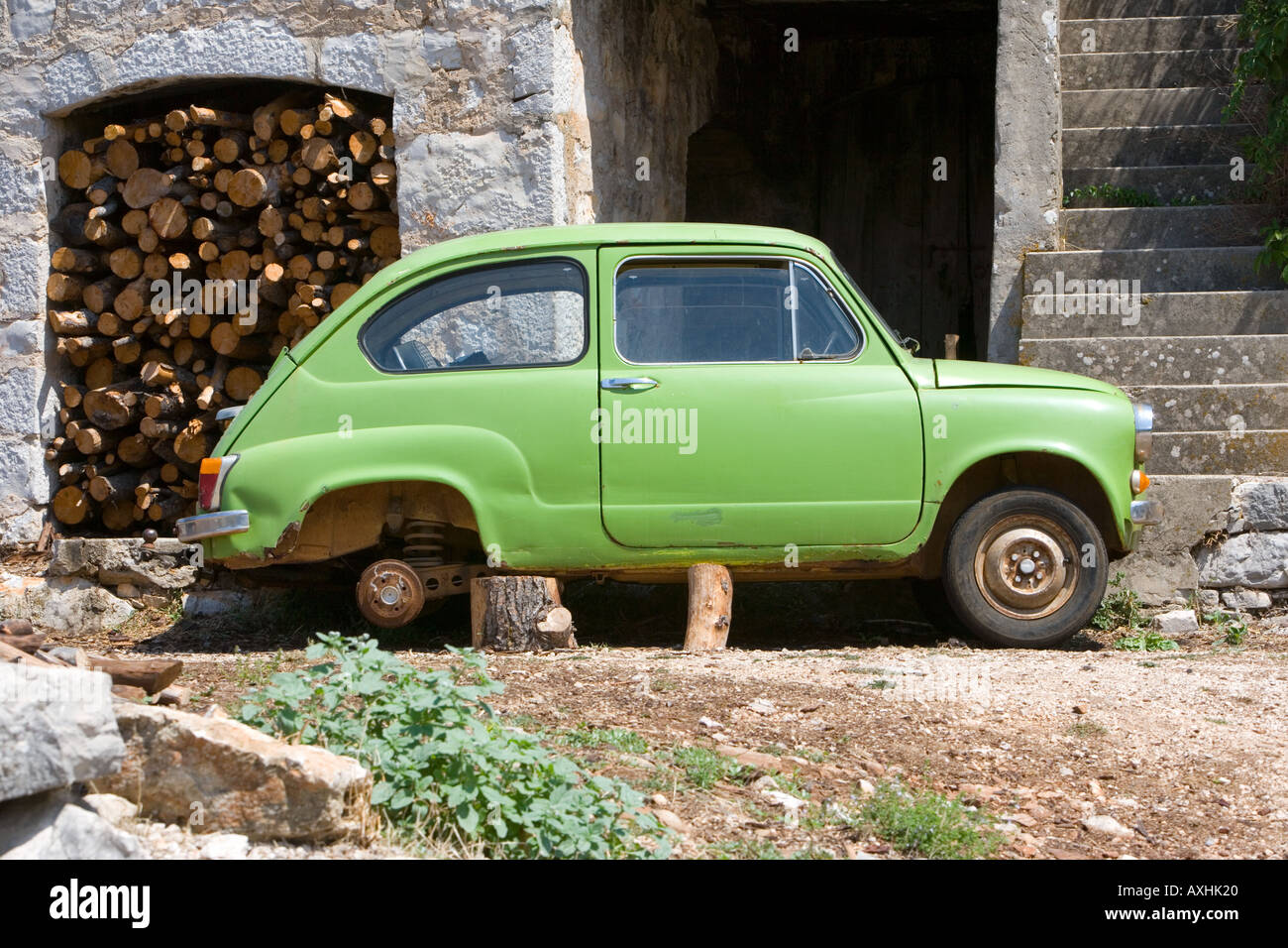 Car without wheel resting on logs Hvar Croatia Stock Photo - Alamy