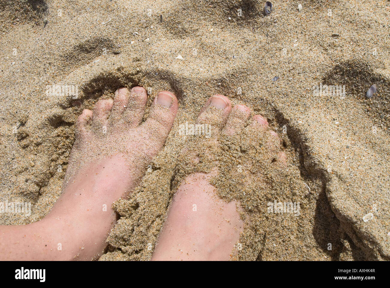 A beach vacation shows a person relaxing with their feet in the soft ...