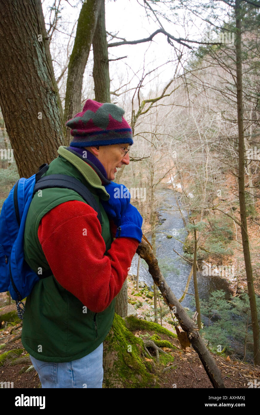 smiling middle age man hiking in woods winter overlooking river in ...