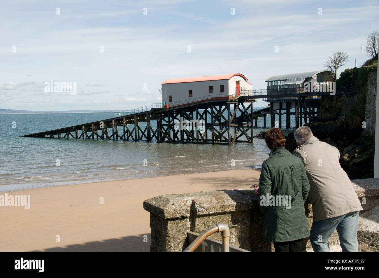 two people leaning on wall looking at The old RNLI inshore lifeboat ...