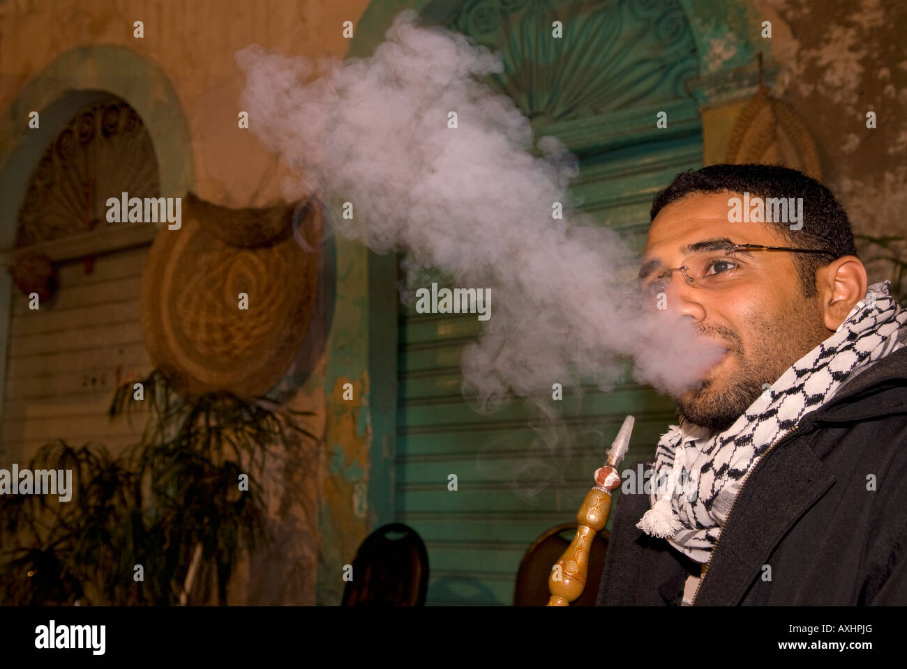 23 year old Palestinian man smoking sheesha pipe in souq al Turk Medina ...