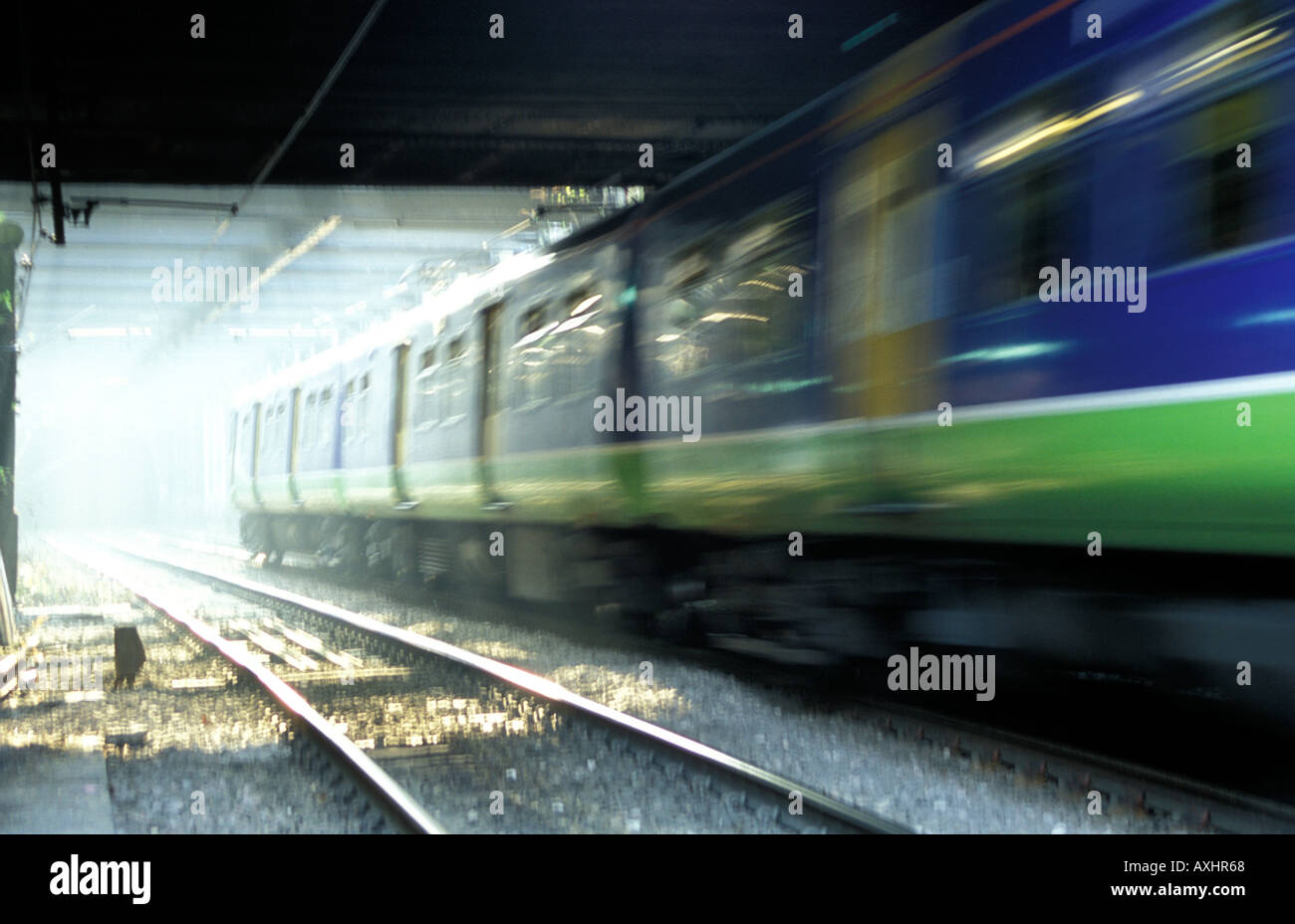 Train passing at high speed under a bridge through a rundown urban ...