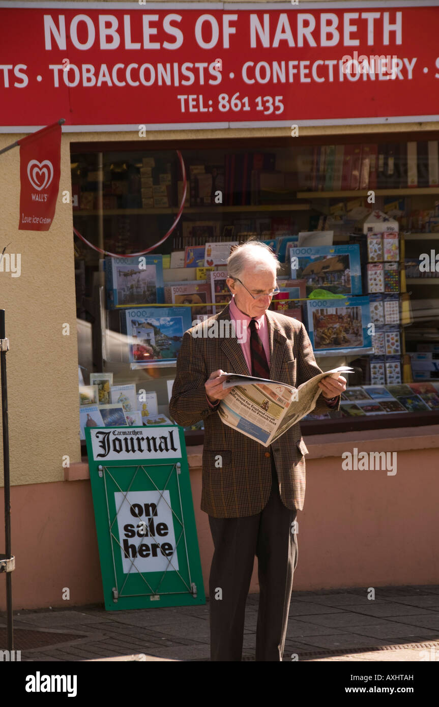 mature adult man reading local newspaper outside newsagent in the ...