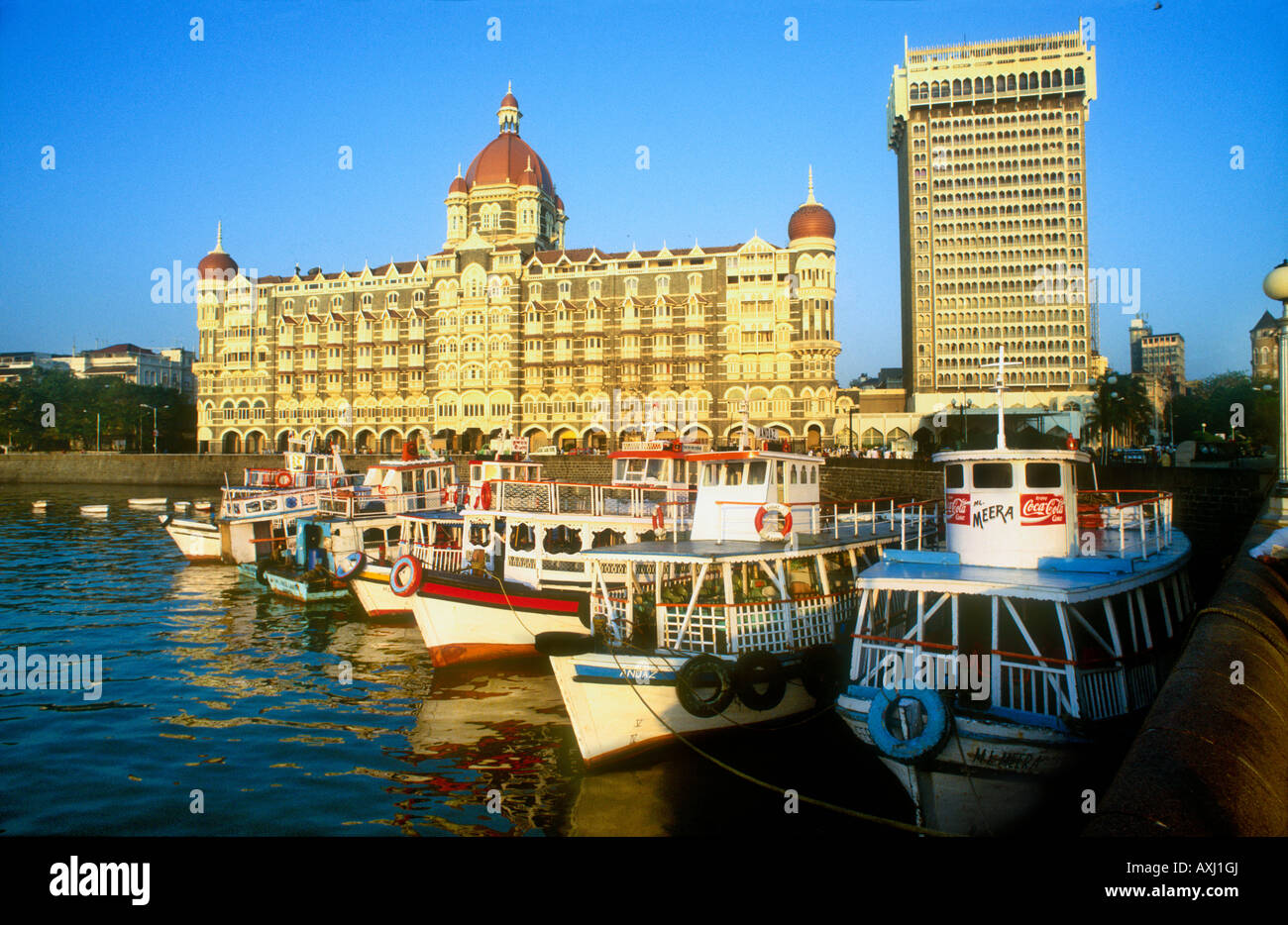 Colourful boats on the Harbour of Bombay with grand colonial building ...
