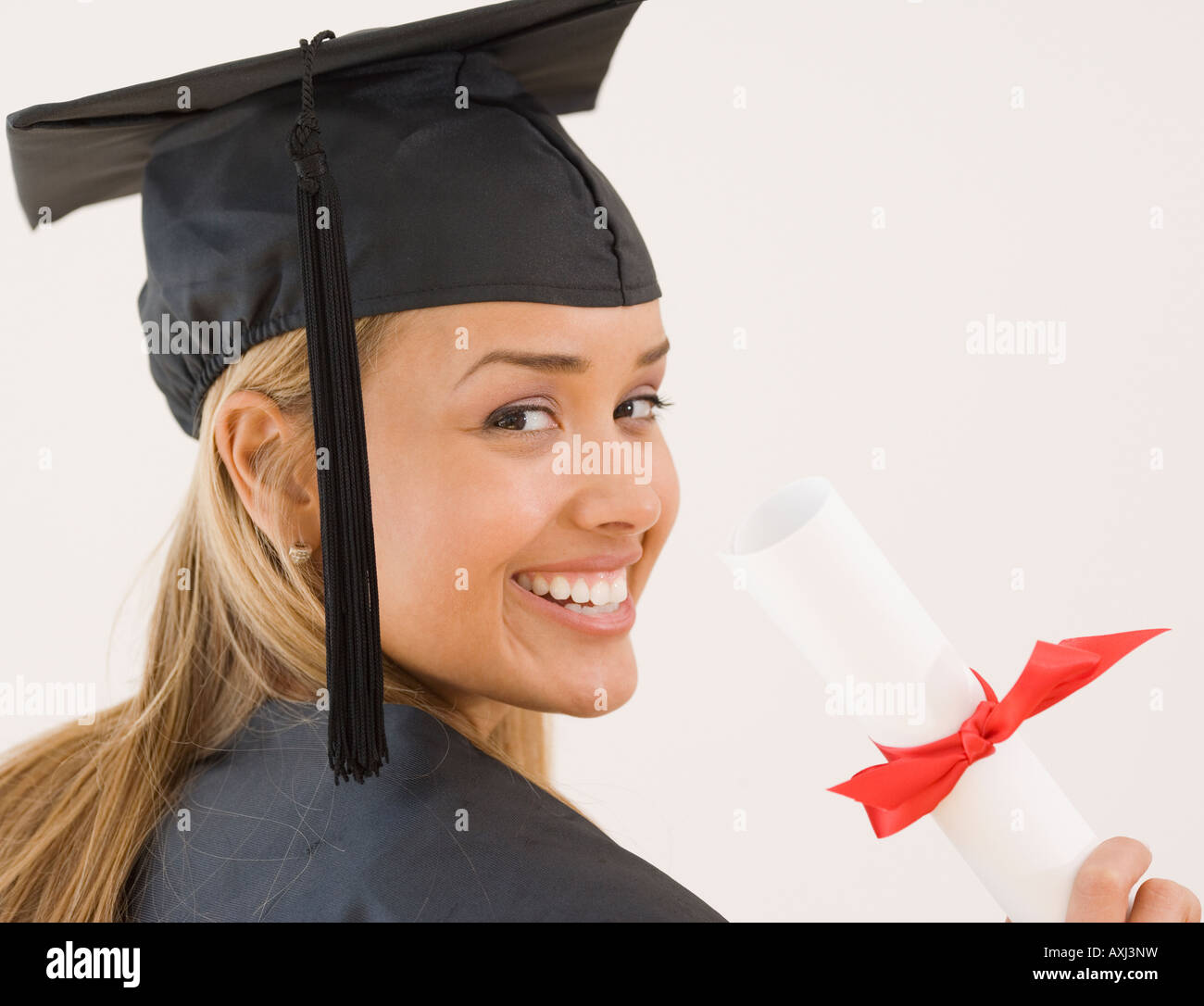 Young Hispanic woman wearing graduation cap and gown Stock Photo - Alamy