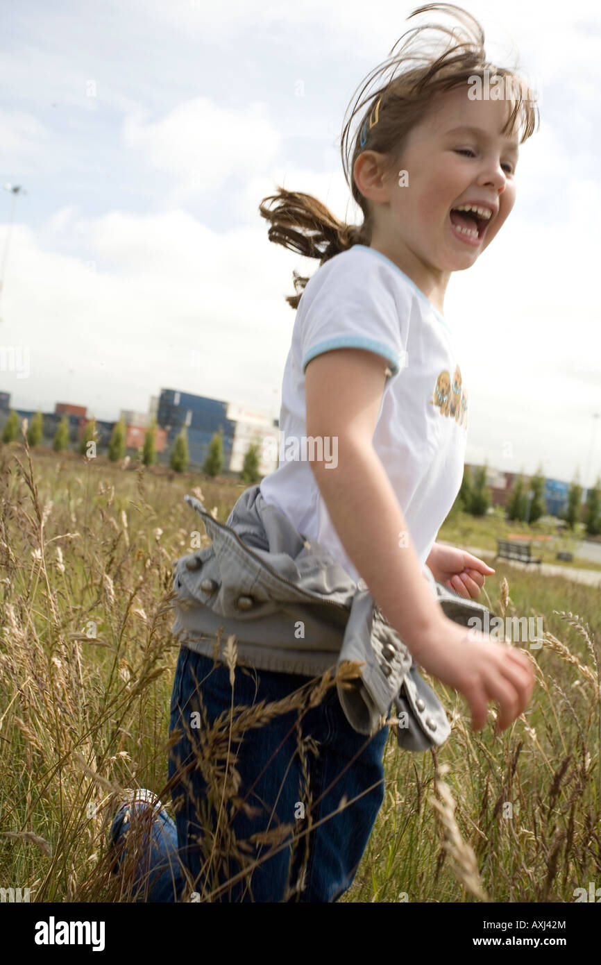 happy girl running through tall grass Stock Photo - Alamy
