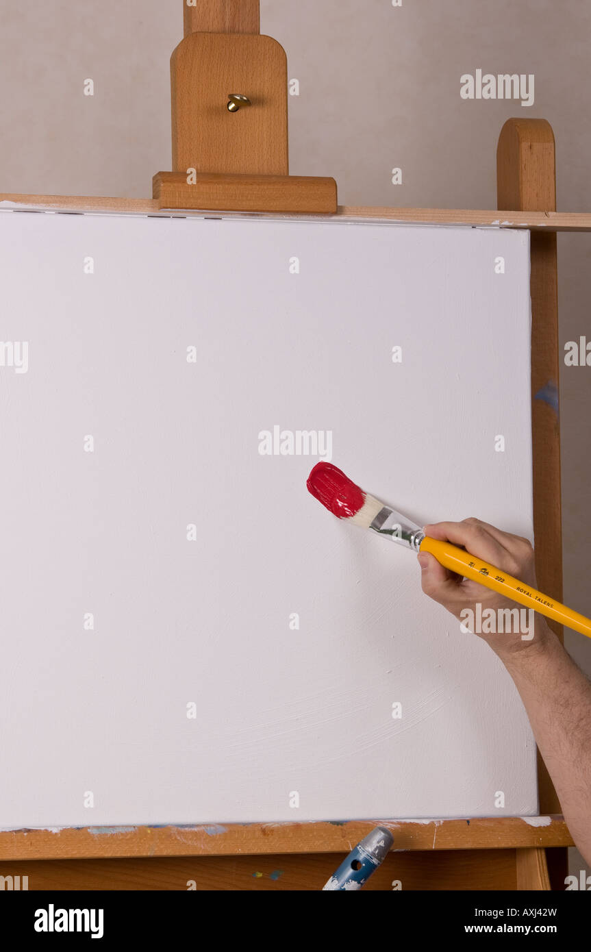 painting on easel with arm hand brush showing colorful Stock Photo - Alamy