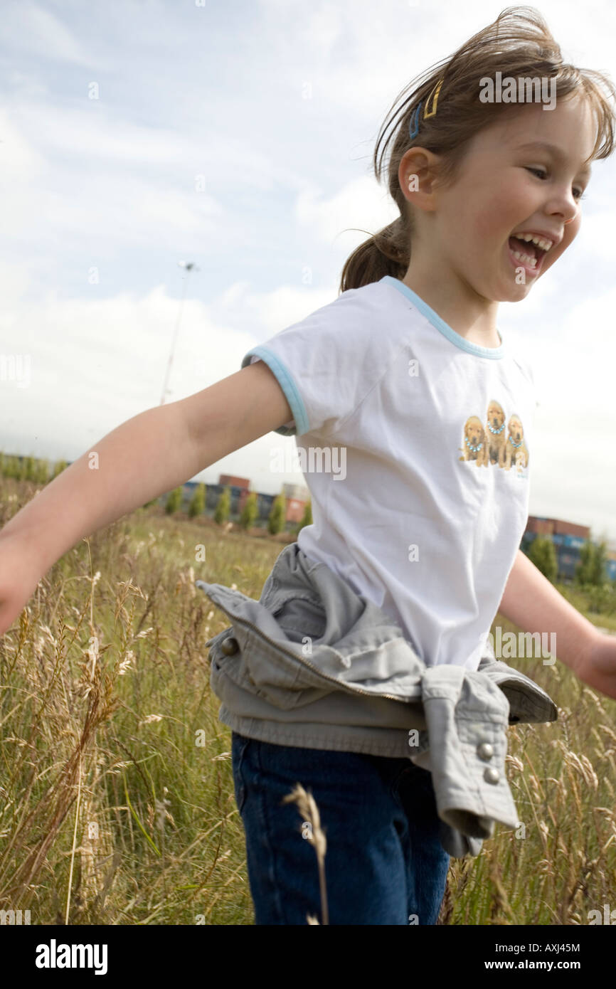 happy girl running through tall grass Stock Photo - Alamy