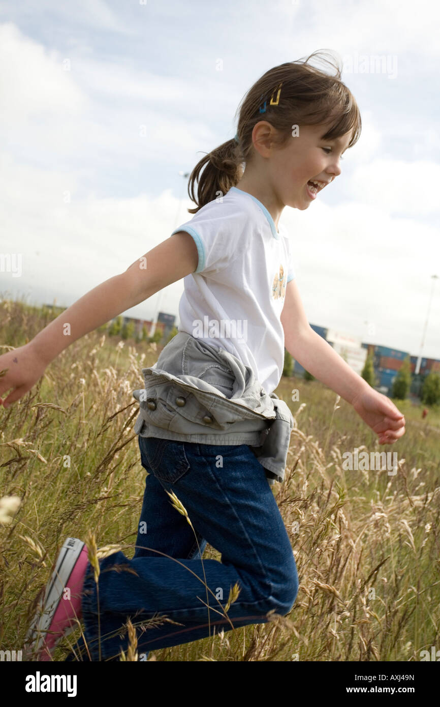happy girl running through tall grass Stock Photo - Alamy