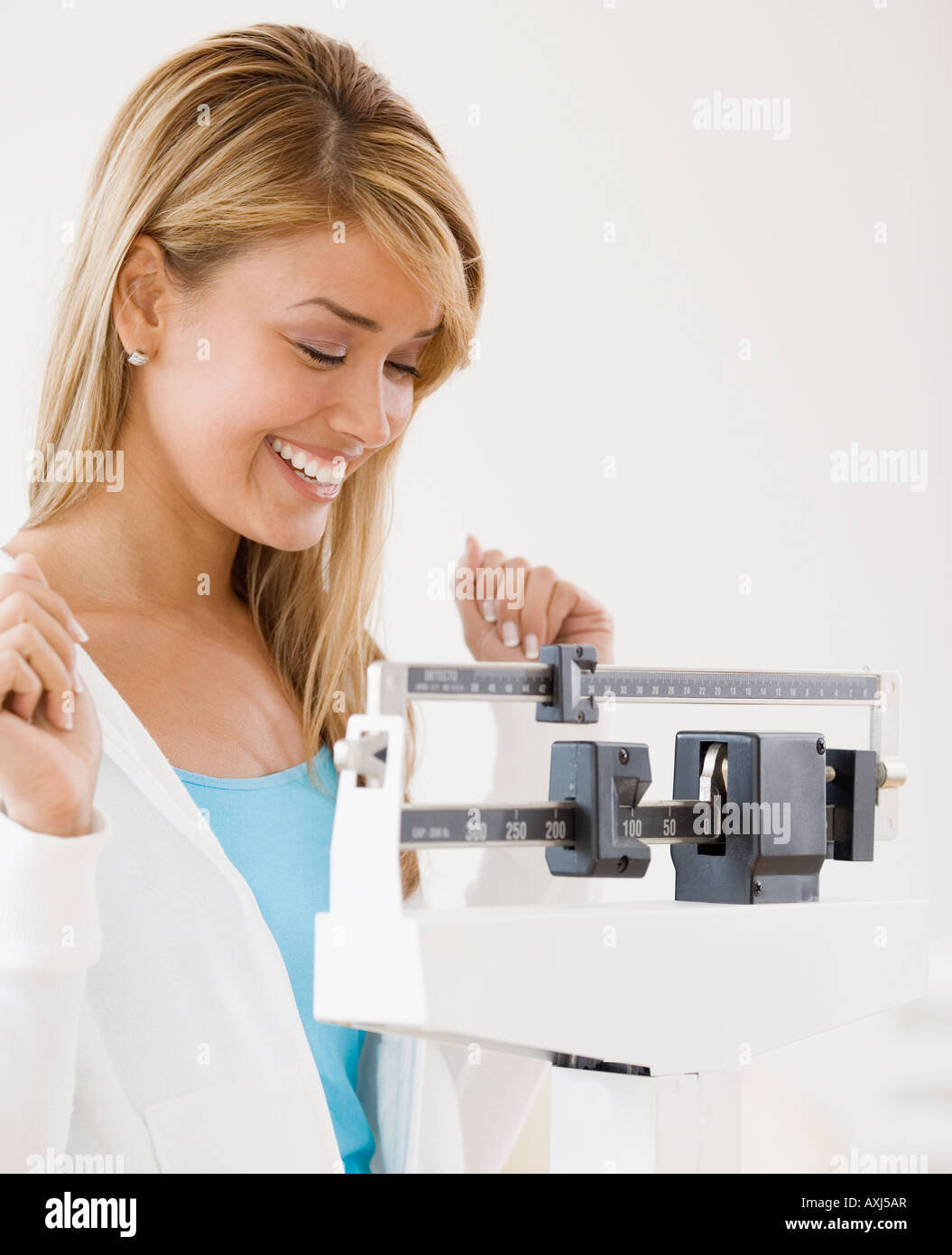Hispanic woman weighing self Stock Photo - Alamy