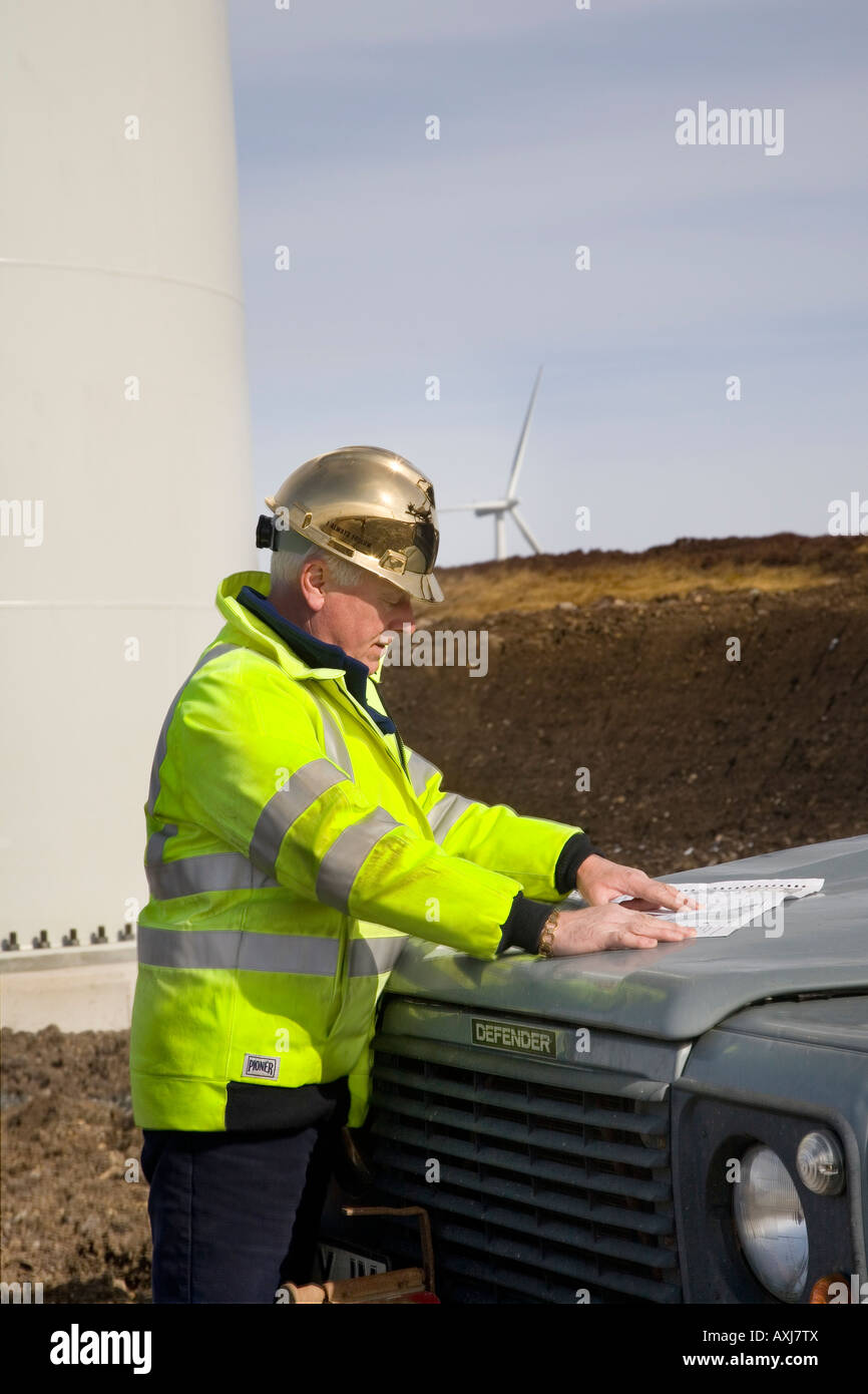 Reviewing Blueprint. A Construction site safety engineer looking at ...