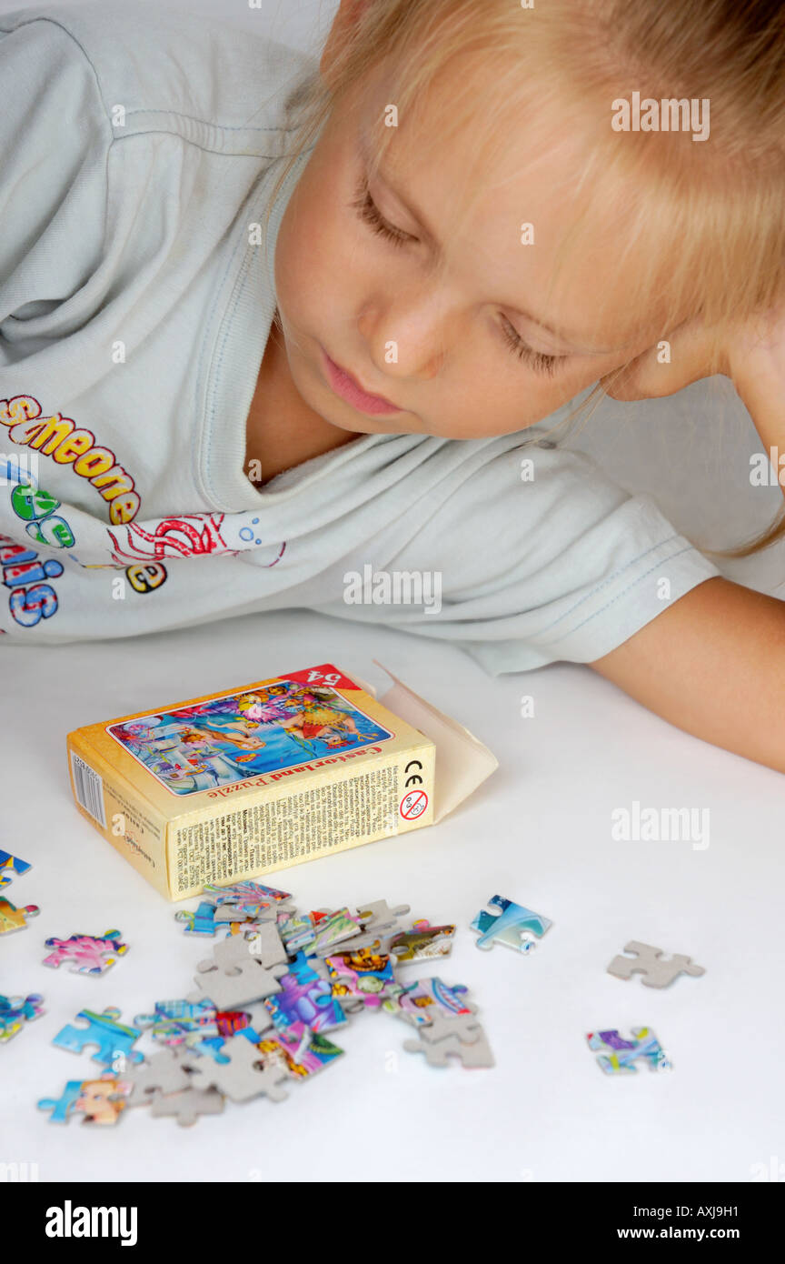 Cute little girl playing puzzles Stock Photo - Alamy
