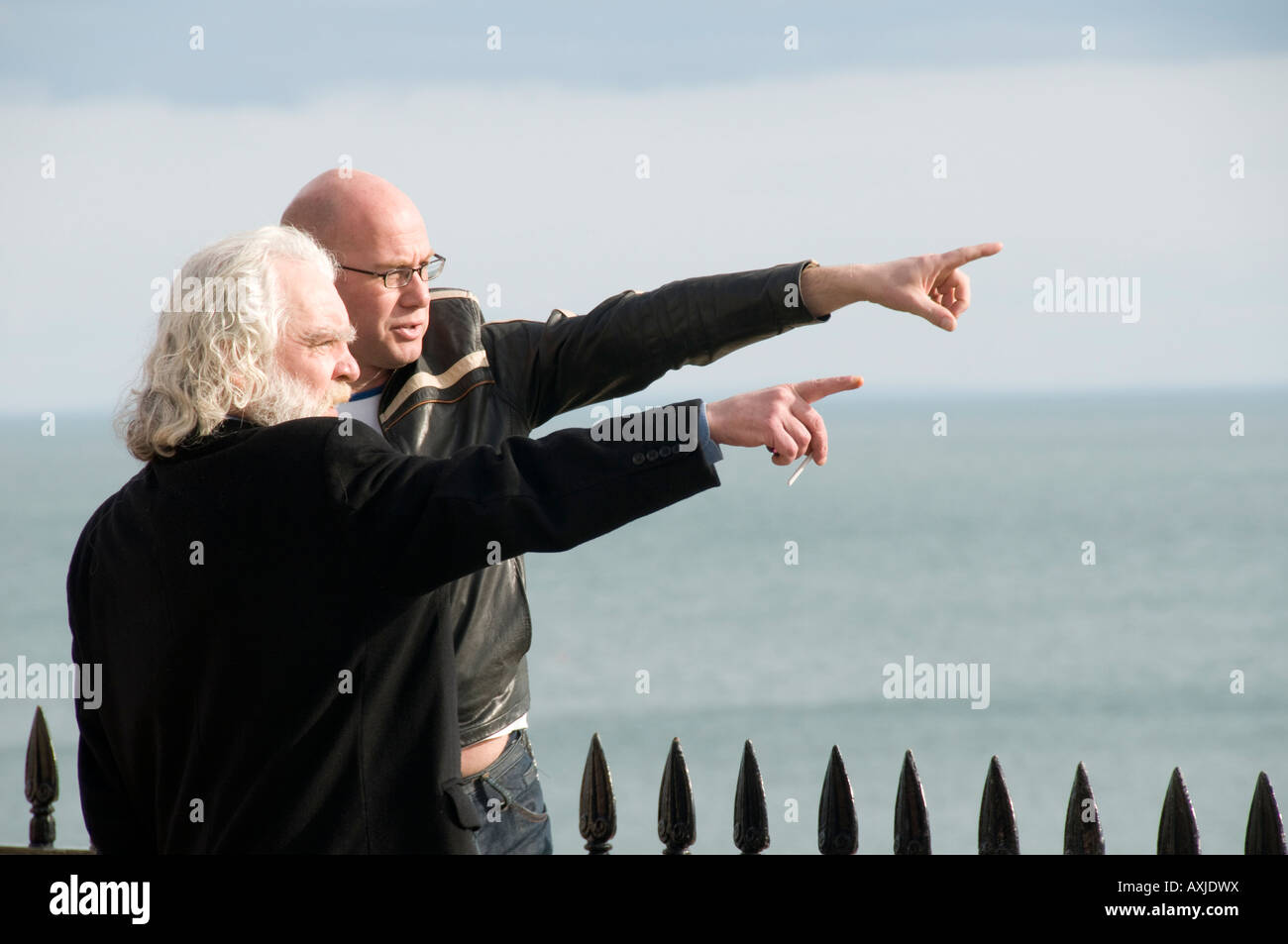 Two adult men pointing Tenby Pembrokeshire Wales UK - asking for and ...