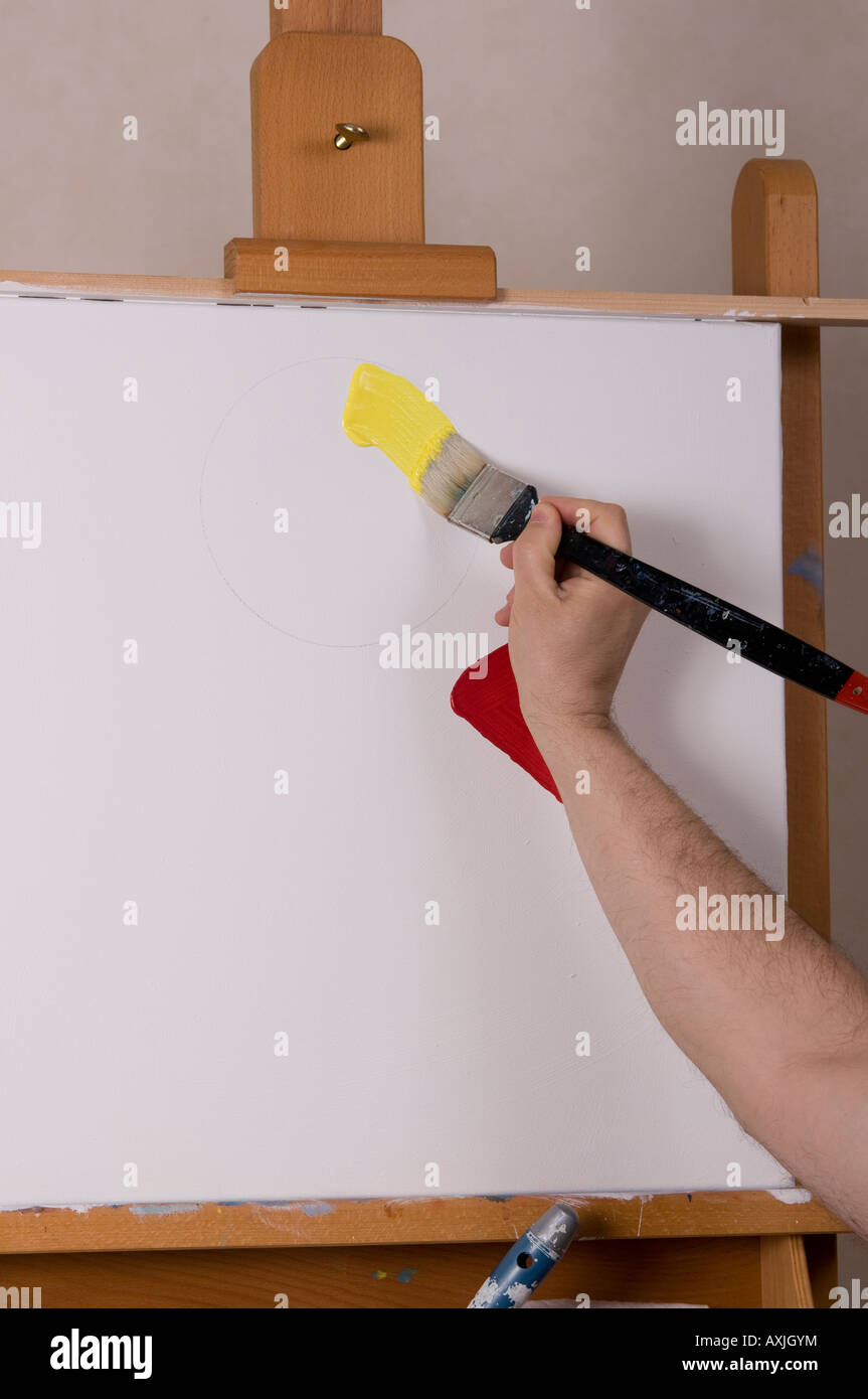 painting on easel with arm hand brush showing colorful Stock Photo - Alamy
