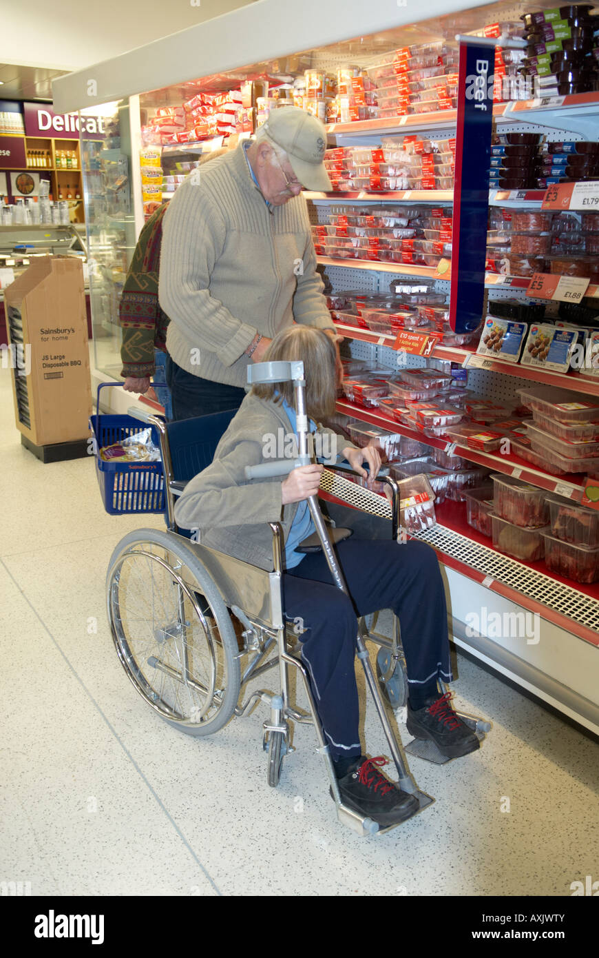 Person in wheelchair shopping in a supermarket with her family Stock ...