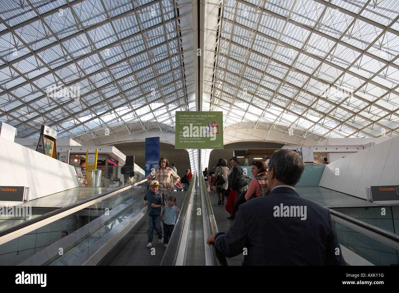Passengers on escalator under steel and glass canopy in Terminal 2F at ...