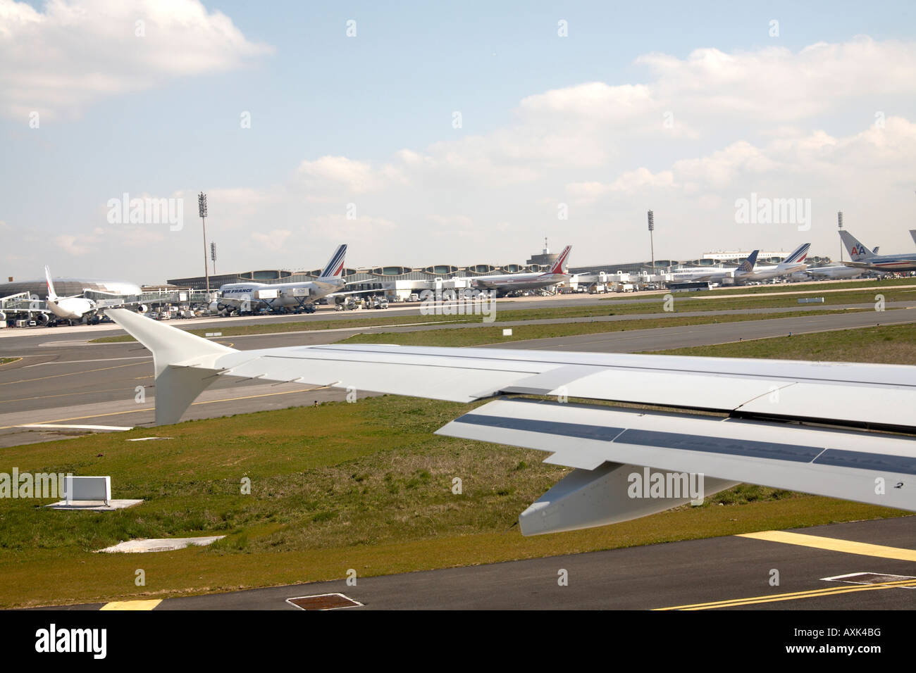 Aircraft parked at teminal building viewed over wing fin of Airbus ...
