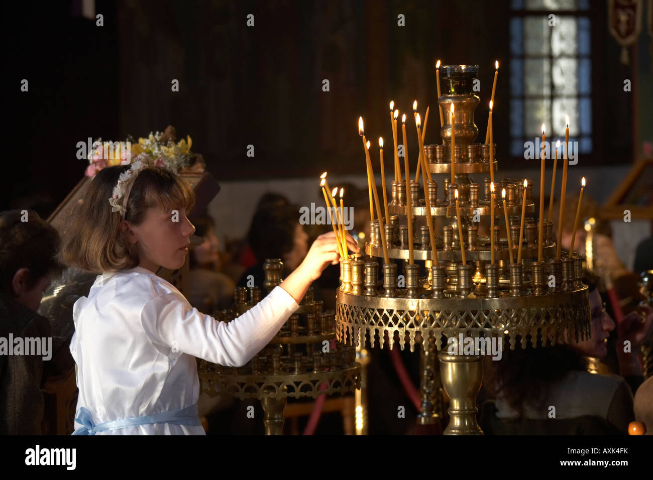 Young girl lighting candles before Easter Good Friday evening service ...