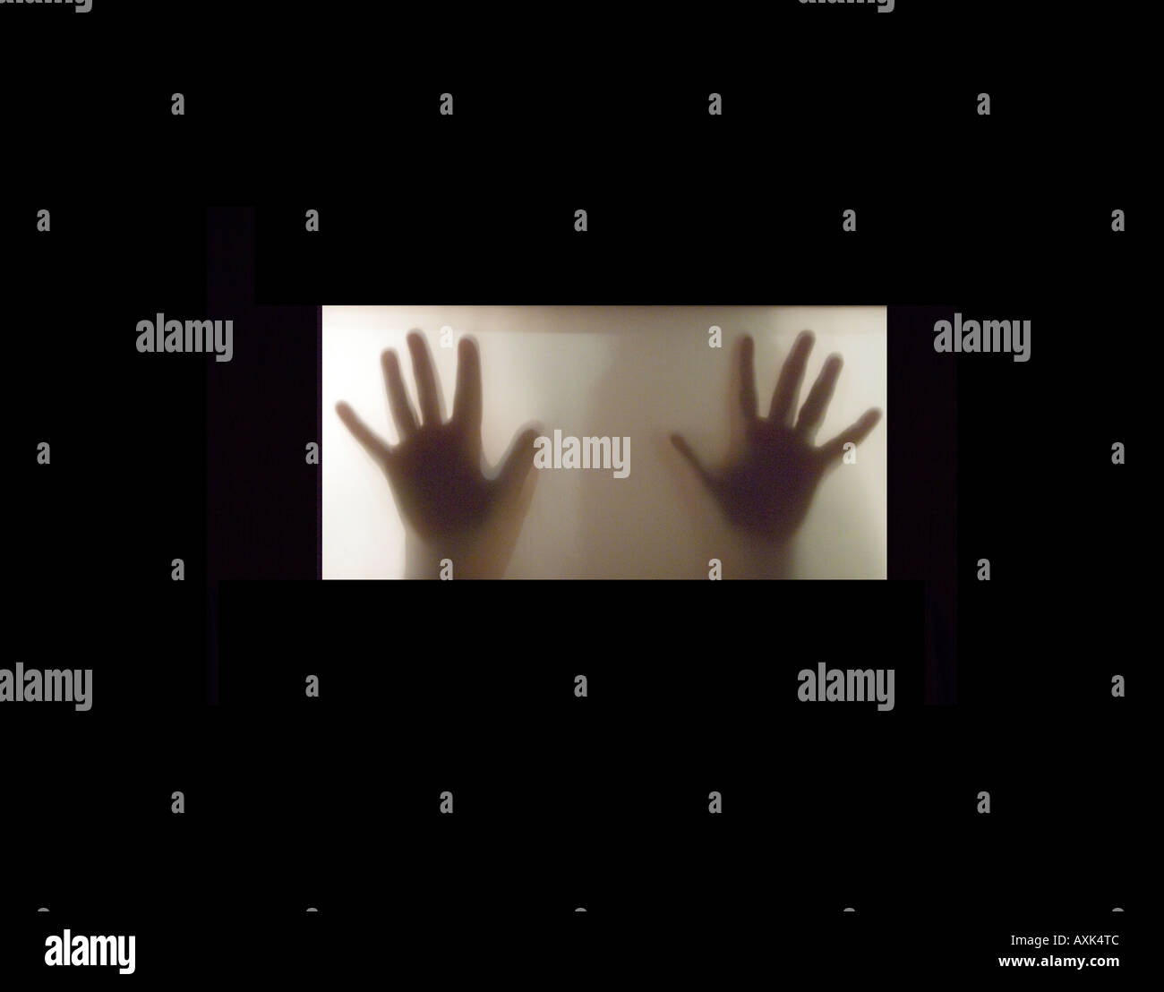 two hands trapped behind a frosted glass window with a black frame ...