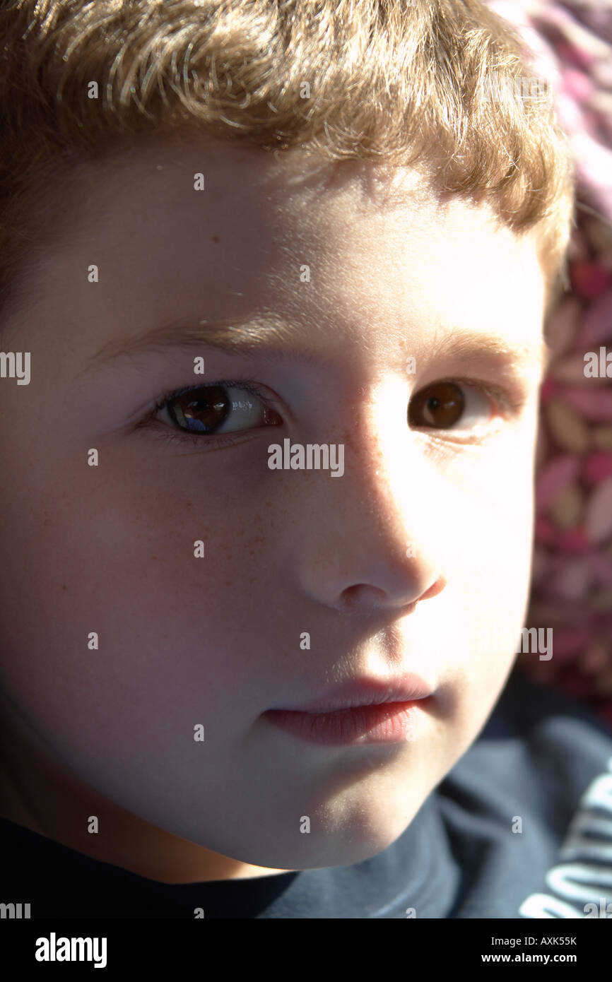 Young boy child with sunlight on far side of face loking serioius NAOH ...