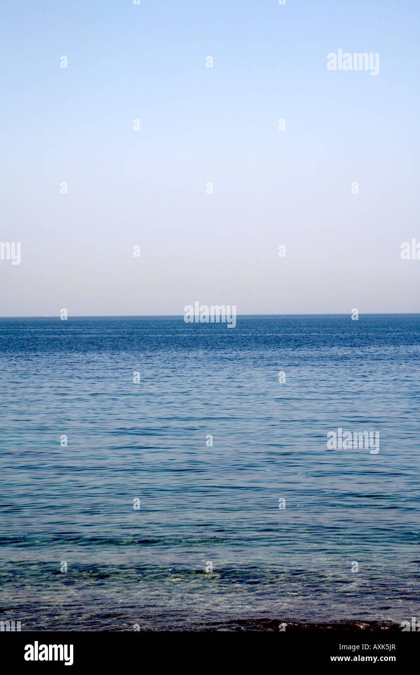 Calm flat sea and horizon reflecting blue of sky from Saronida in ...