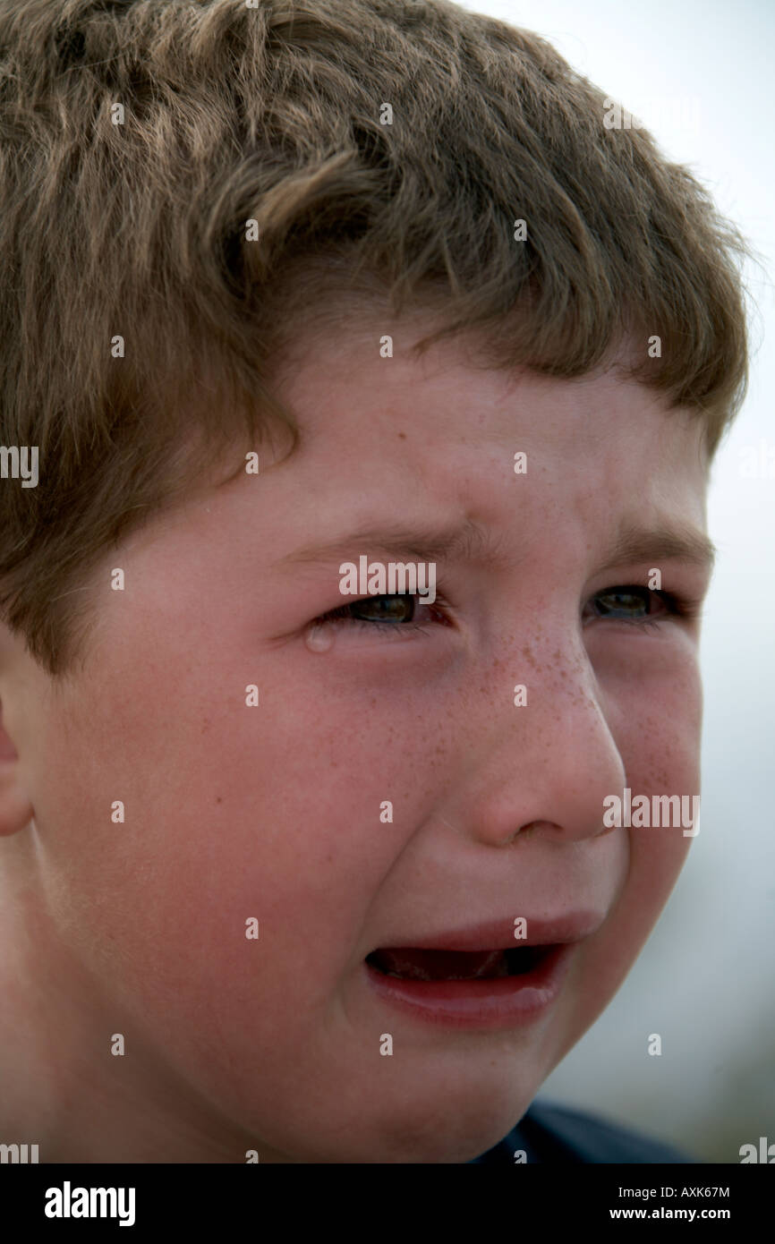 Young boy child miserable unhappy sad crying with tears rolling down ...