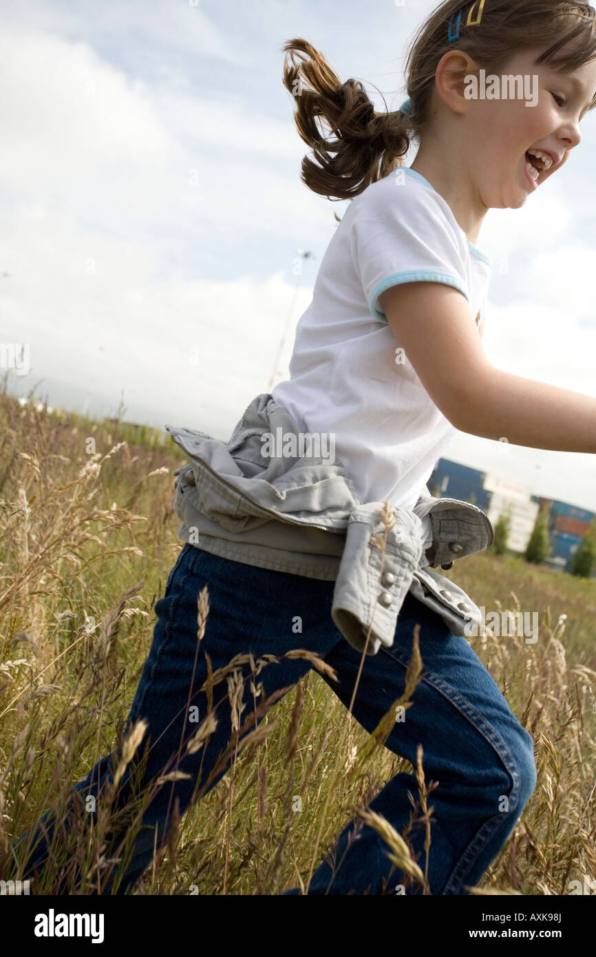 happy girl running through tall grass Stock Photo - Alamy