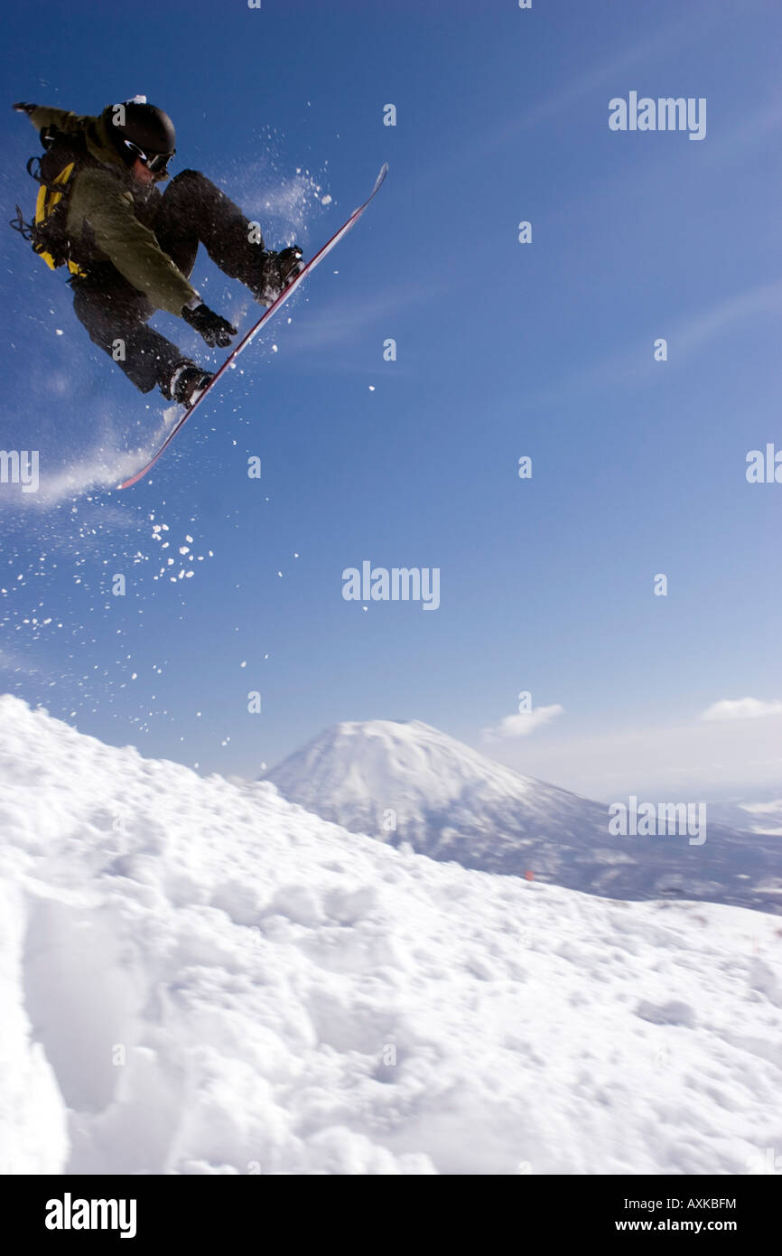 Flying high, a daring snowboarder is doing impressive tricks on a ...