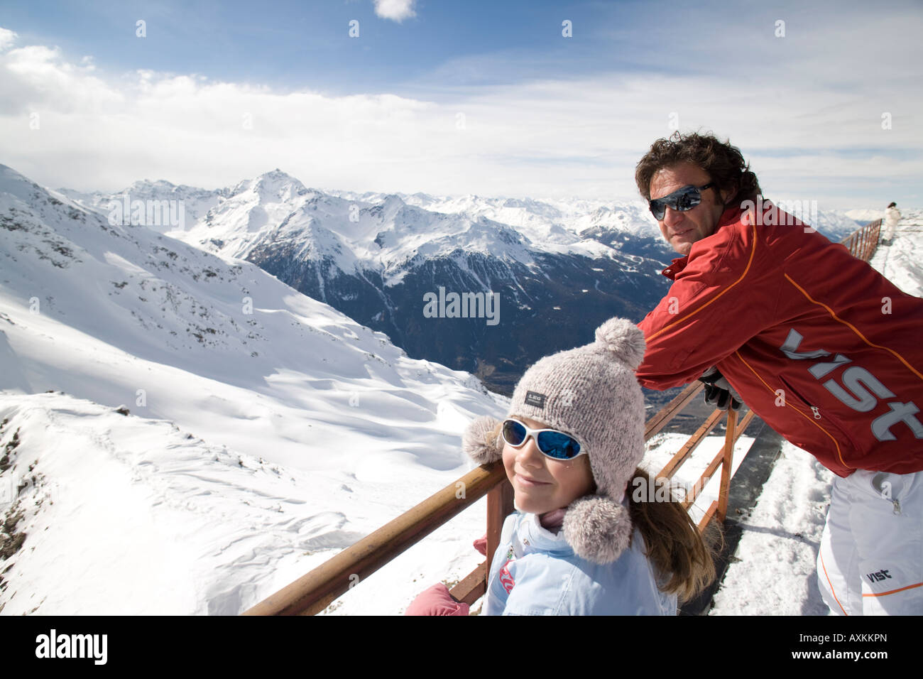 Father and daughter on a terrace at Bormio 3000 watching the alpine ...
