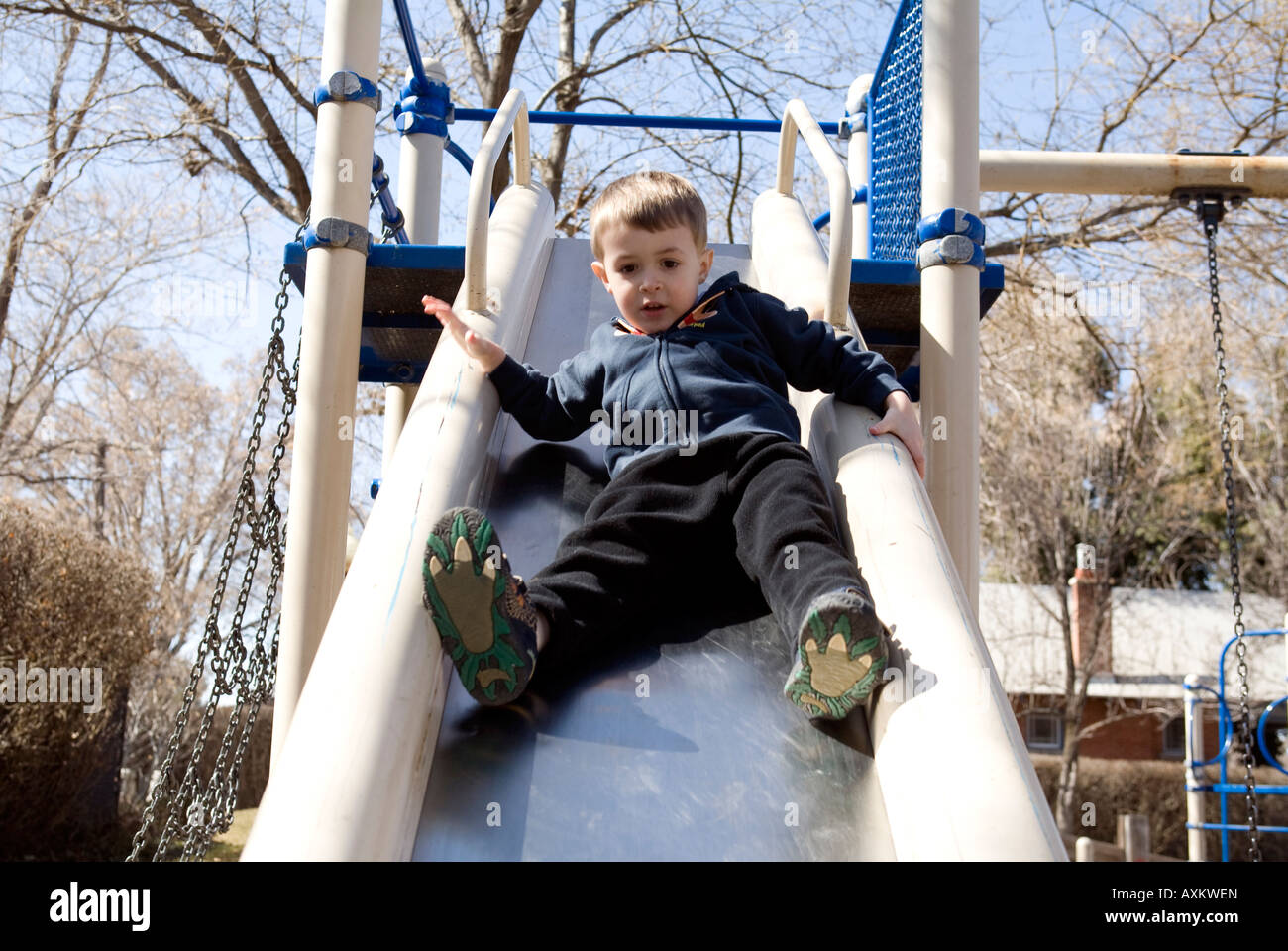 a young boy works up the nerve to go down a slide at a park in salt ...