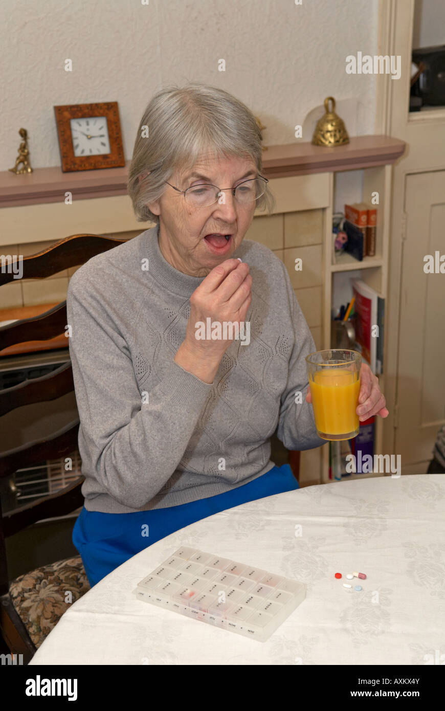 Elderly lady preparing to take her medication at home Stock Photo - Alamy