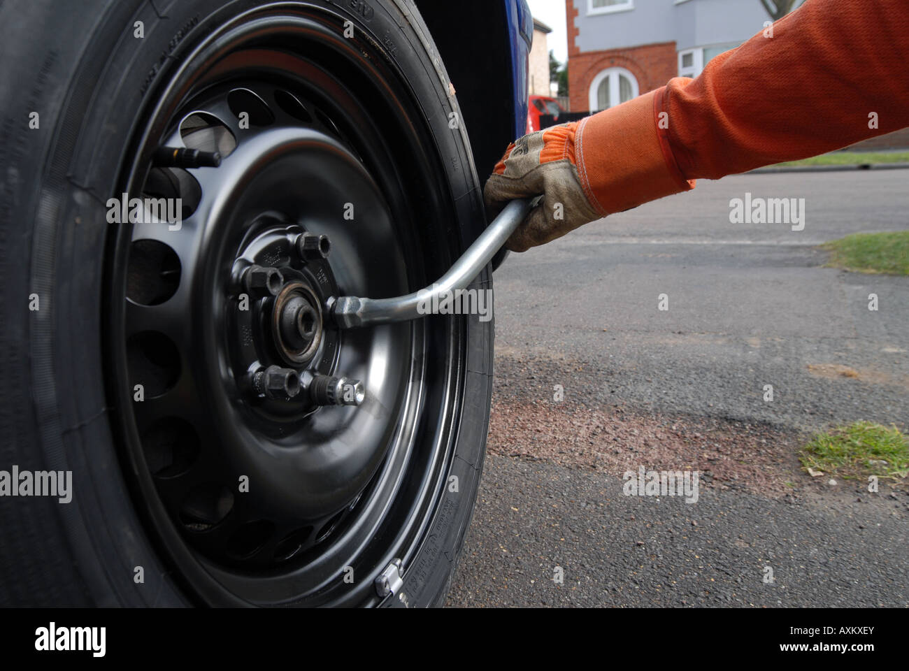 A car driver changes a wheel after a puncture Stock Photo - Alamy