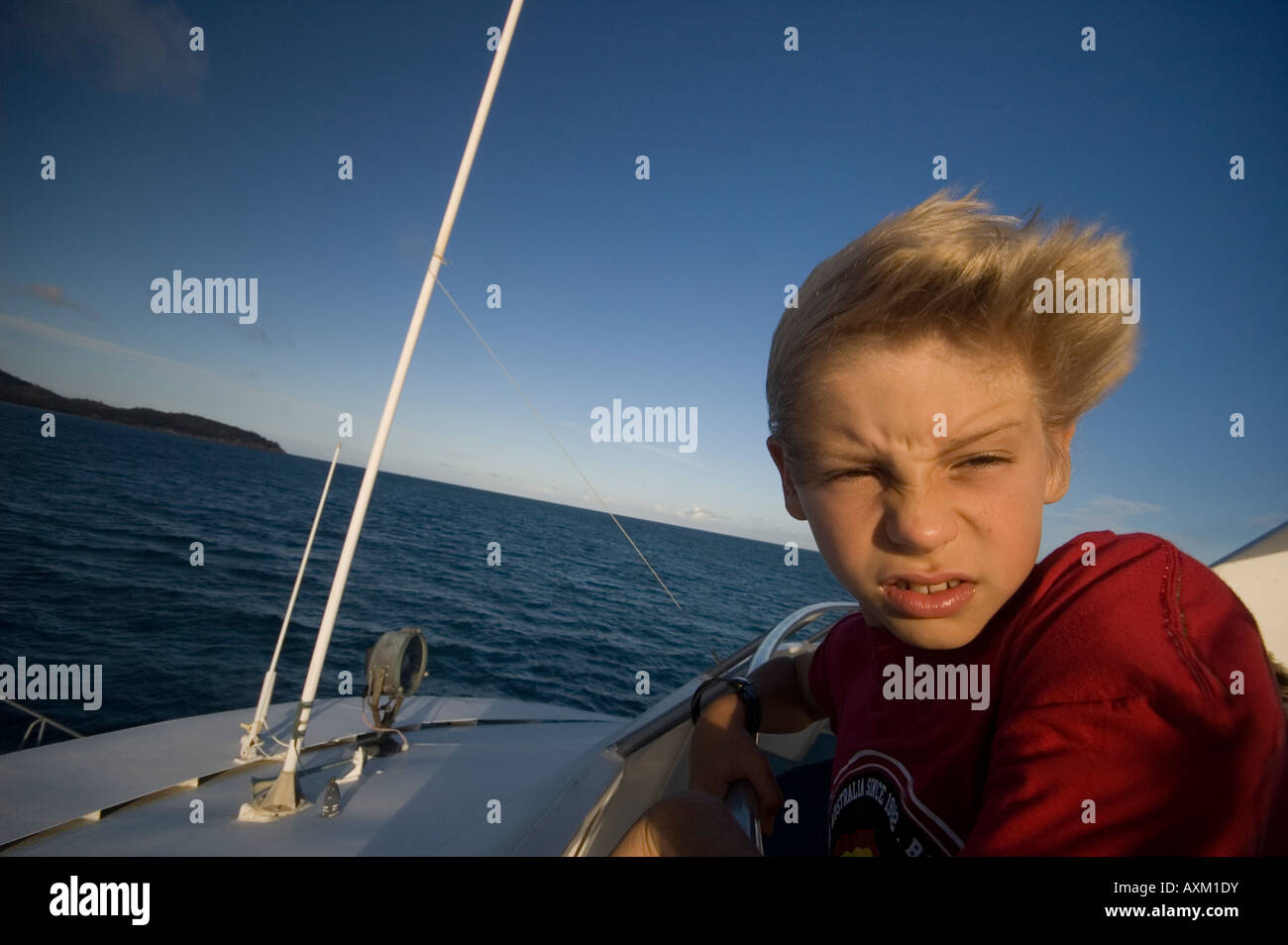 wind blown young boy on deck of boat Stock Photo - Alamy